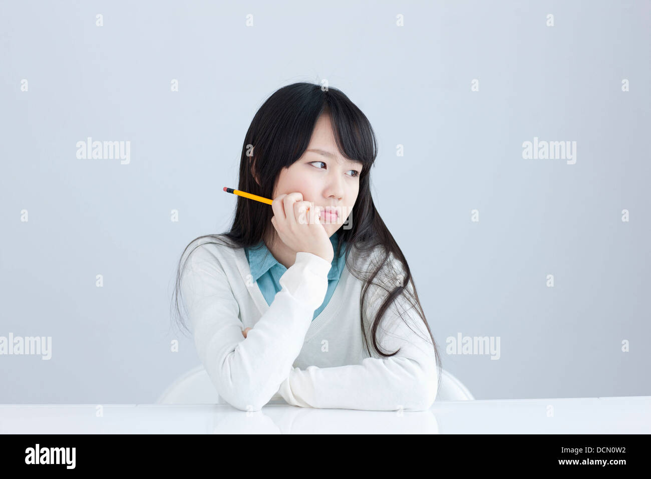 a lady leaning on a desk with a pencil Stock Photo - Alamy