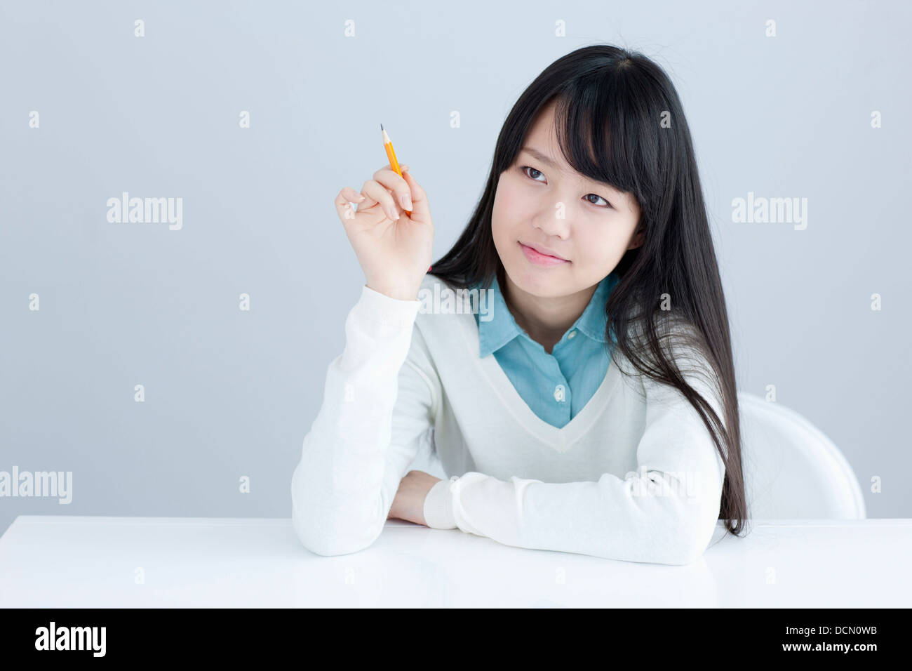 a lady leaning on a desk with a pencil Stock Photo - Alamy