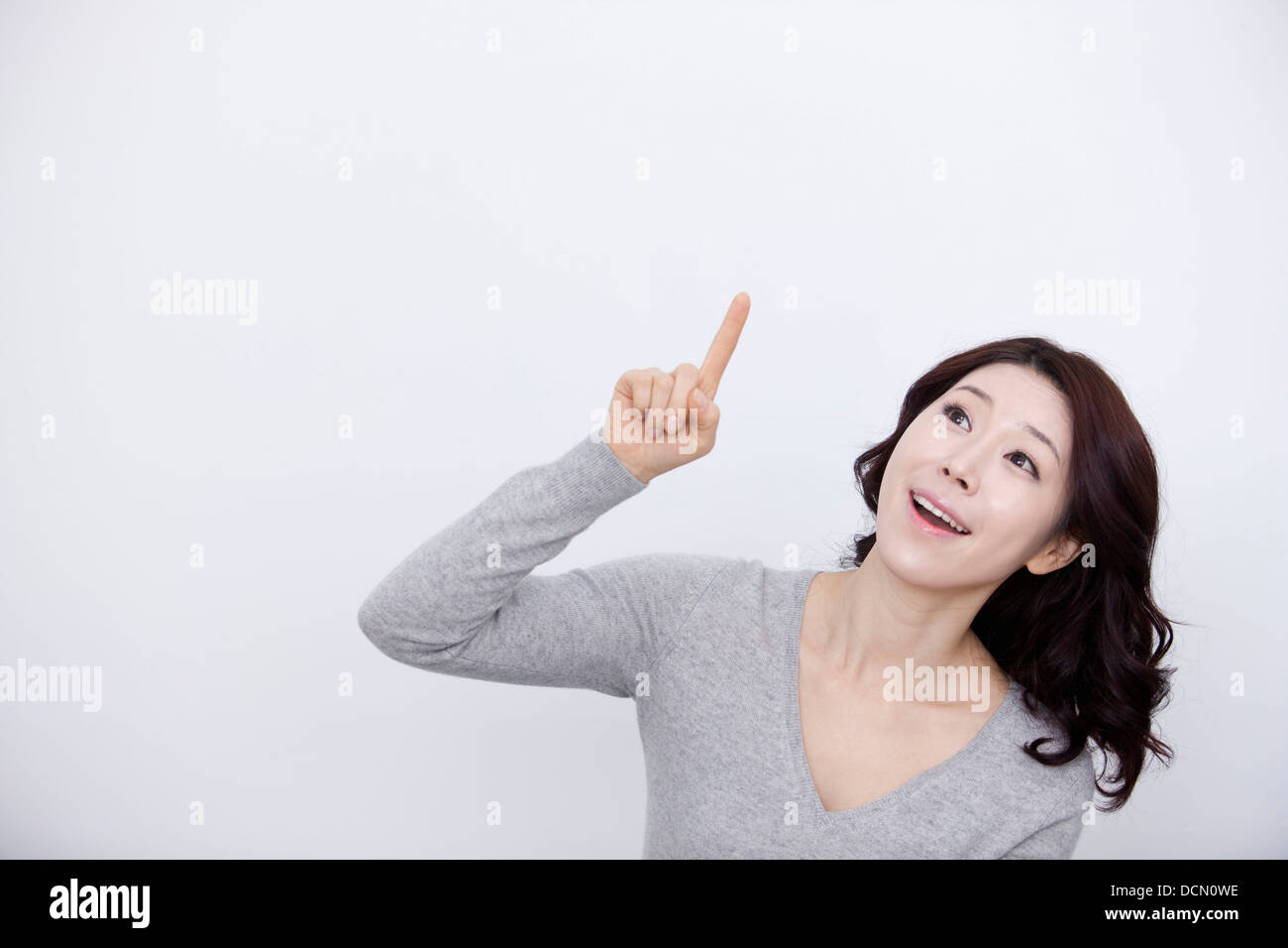 a woman in grey plain shirt smiling Stock Photo - Alamy