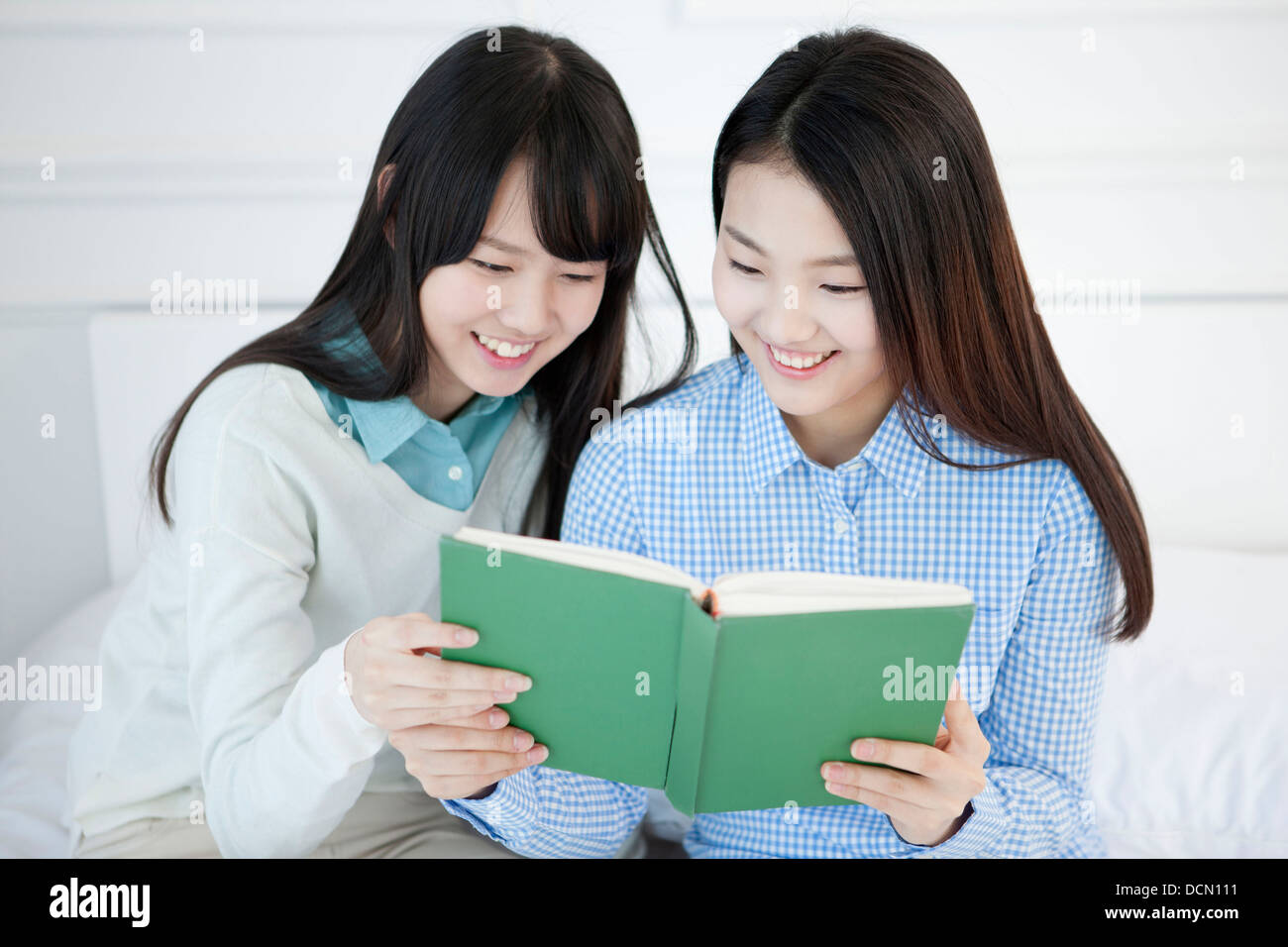 two ladies reading a book together Stock Photo - Alamy