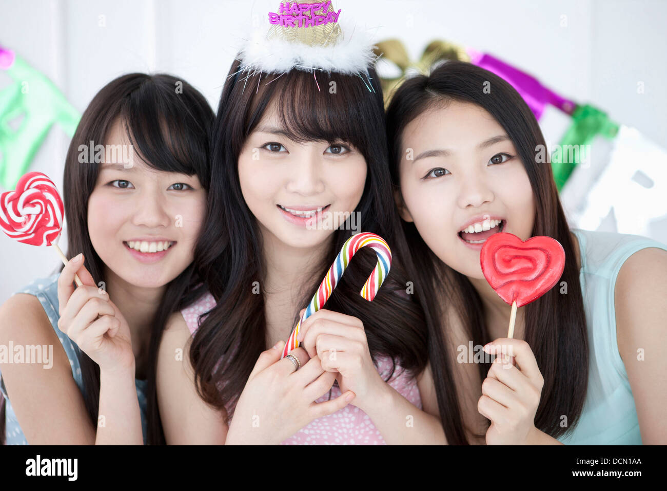 ladies posing with lollipops in the party Stock Photo - Alamy
