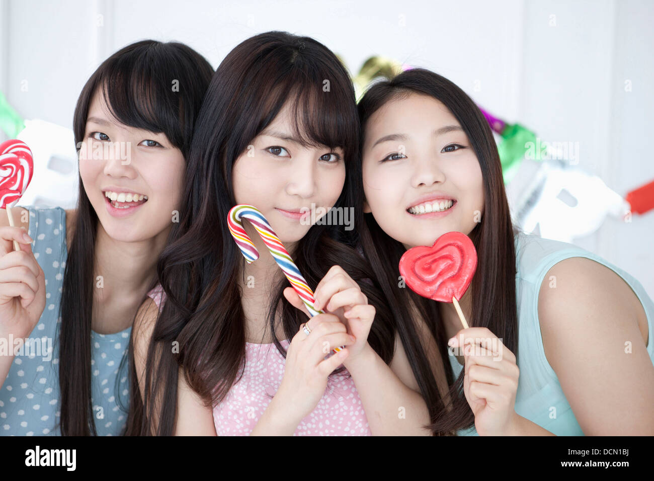 ladies posing with lollipops in the party Stock Photo - Alamy