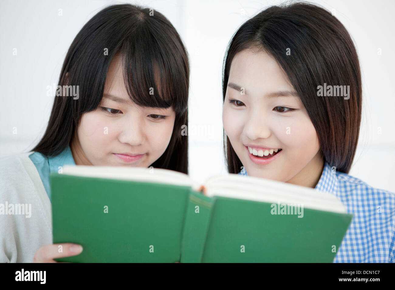 two ladies reading a book together Stock Photo - Alamy