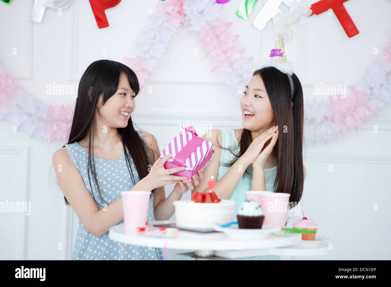 a lady giving a present to her friend Stock Photo - Alamy