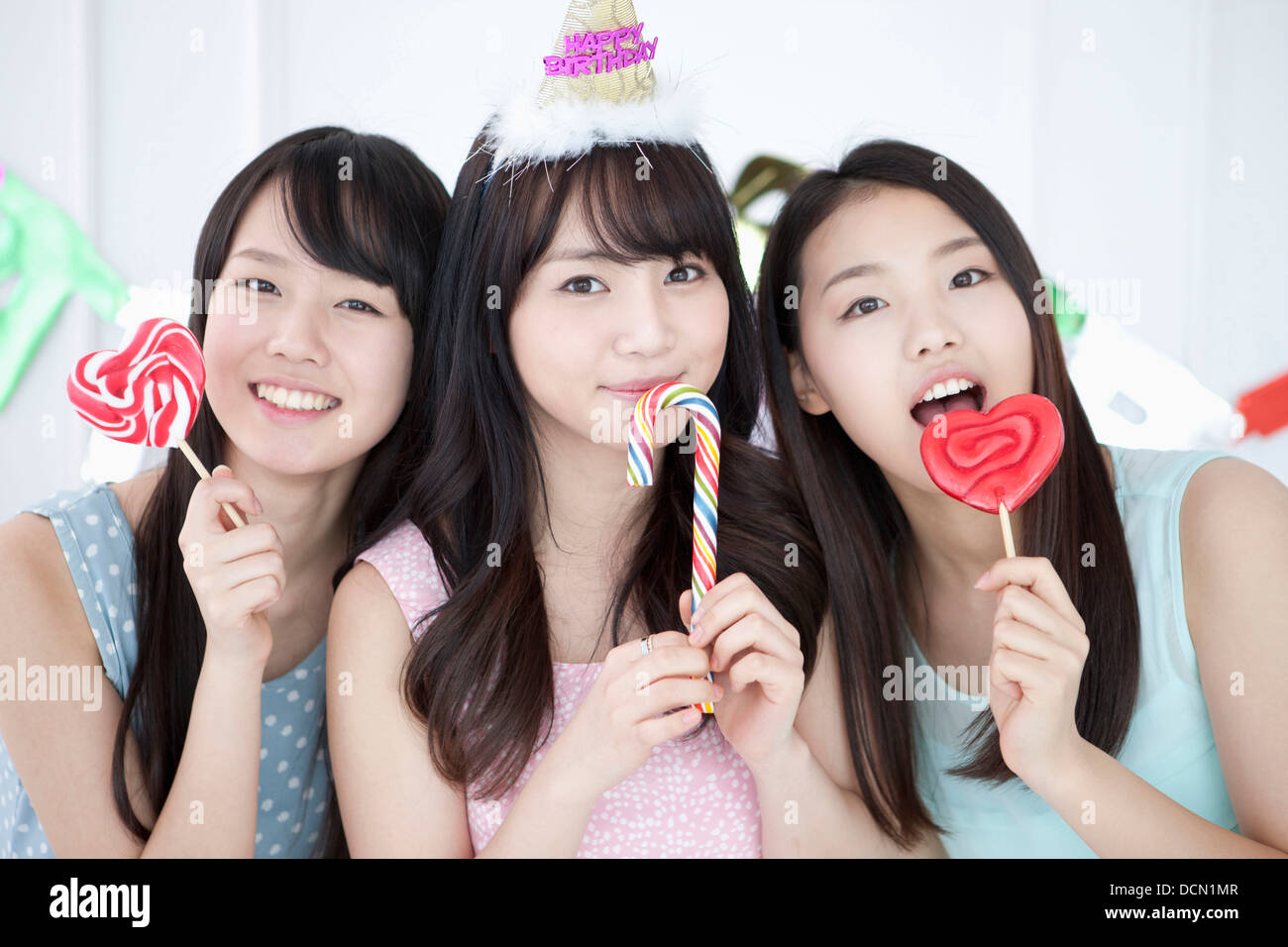 ladies posing with lollipops in the party Stock Photo - Alamy