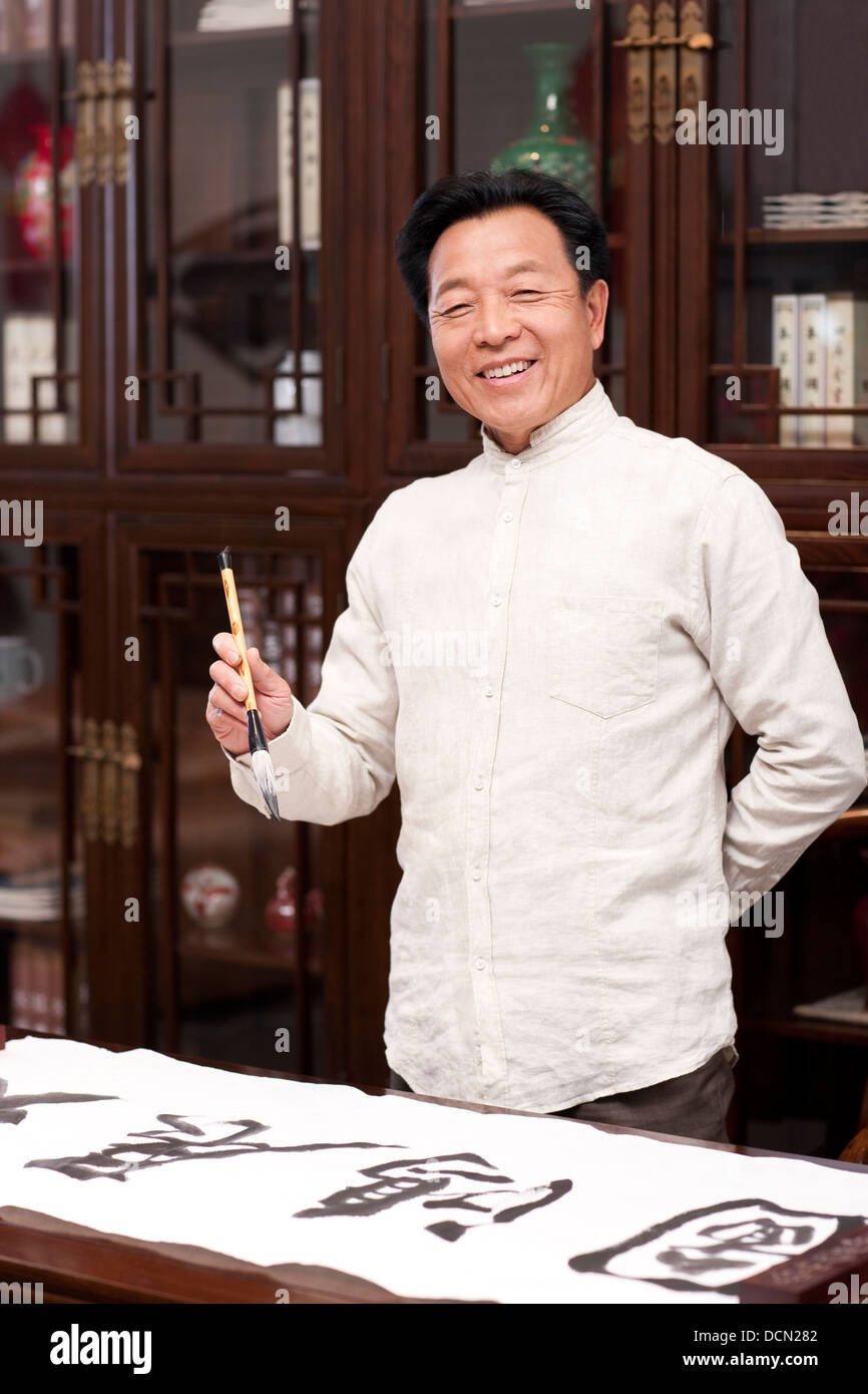 Senior man practicing calligraphy in the study Stock Photo - Alamy