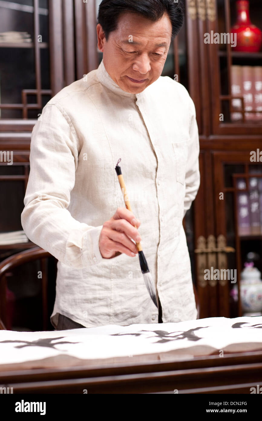 Senior man practicing calligraphy in the study Stock Photo - Alamy