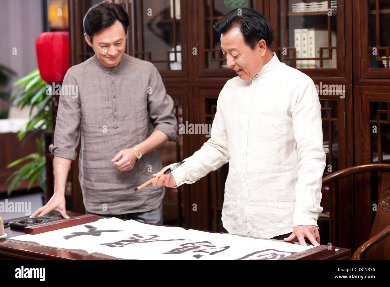 Male friends practicing calligraphy in the study Stock Photo - Alamy