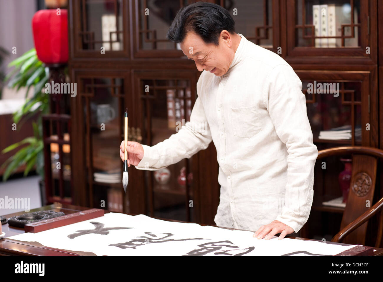Senior man practicing calligraphy in the study Stock Photo - Alamy