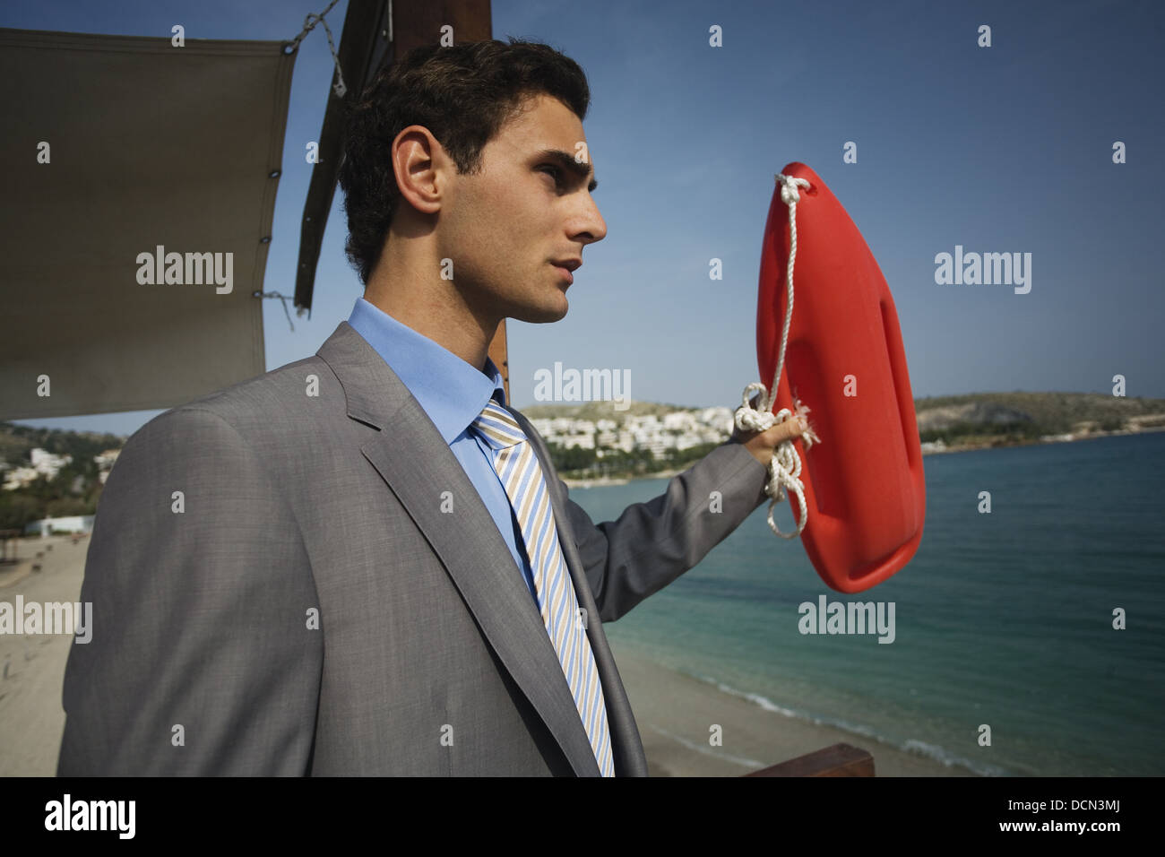 Businessman on life guard stand with life preserver Stock Photo - Alamy