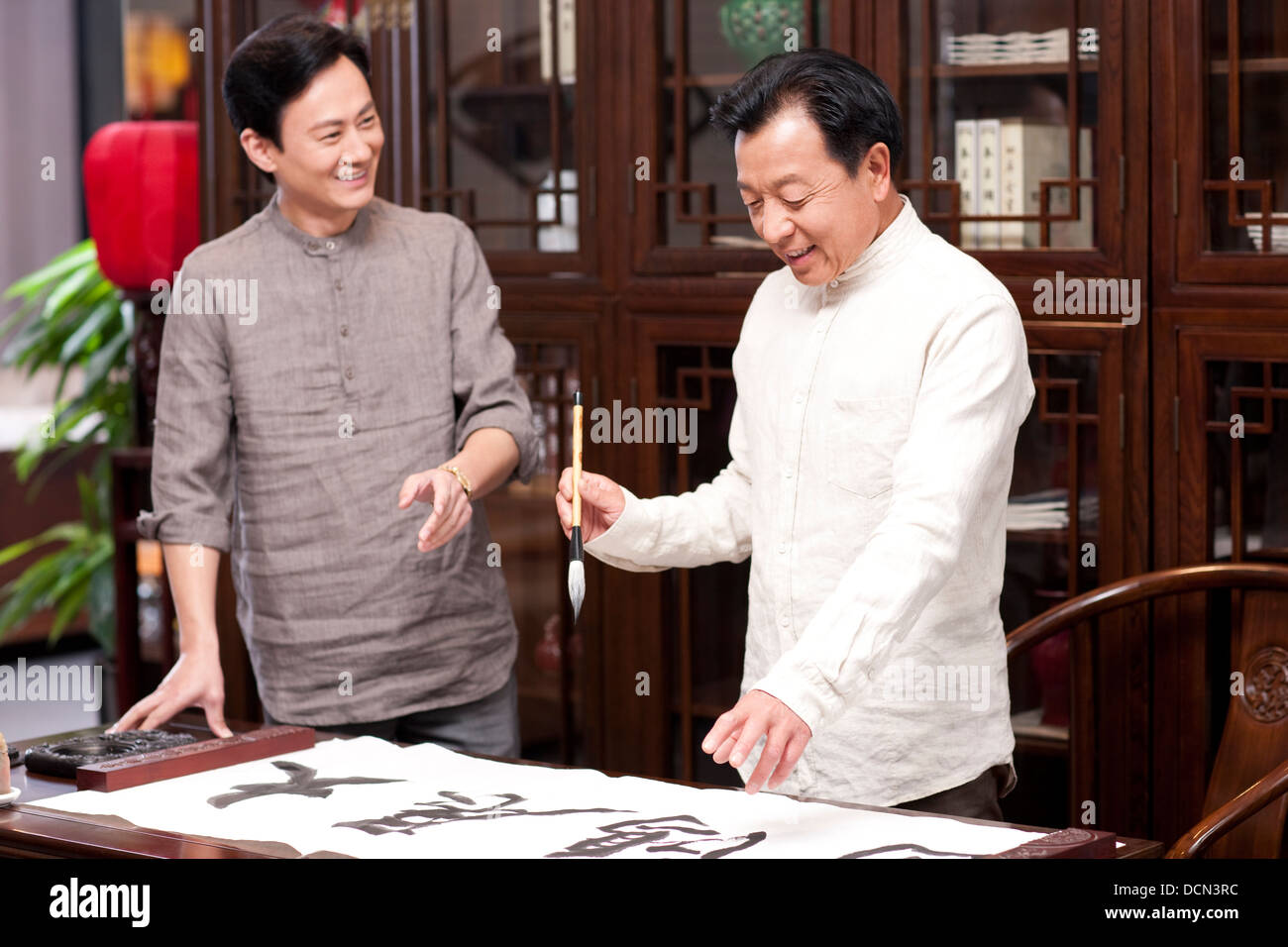 Male friends practicing calligraphy in the study Stock Photo - Alamy