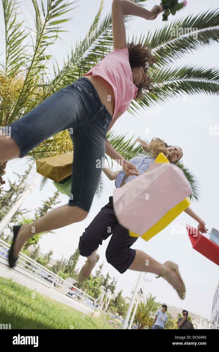 Women with shopping bags jumping Stock Photo - Alamy