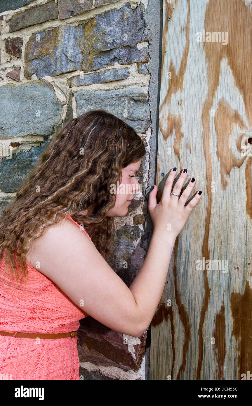 Teen Girl peeking through a window of an old stone building Stock Photo ...