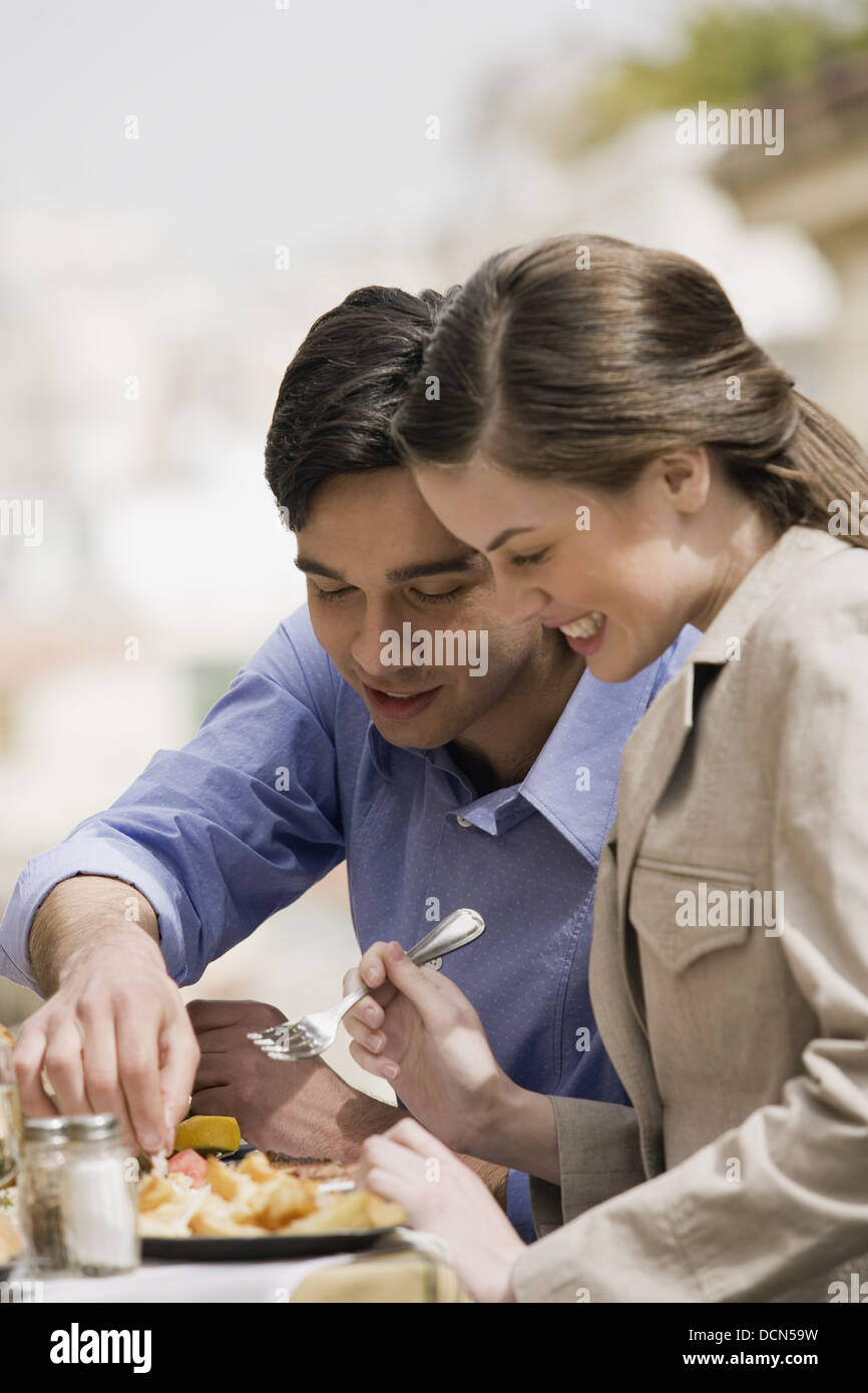 Couple at a table eating Stock Photo - Alamy