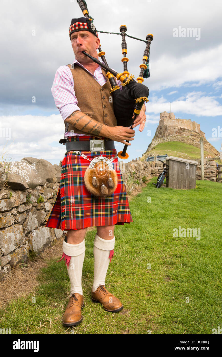 A piper playing outside Lindisfarne Castle, Holy Island, Northumberland ...