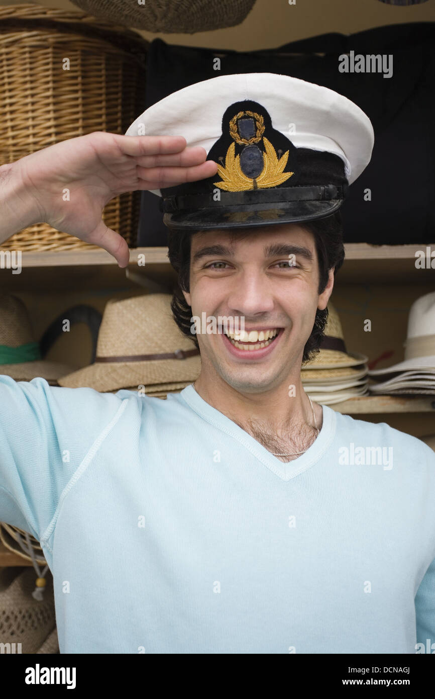 Man trying on naval hat, saluting Stock Photo - Alamy