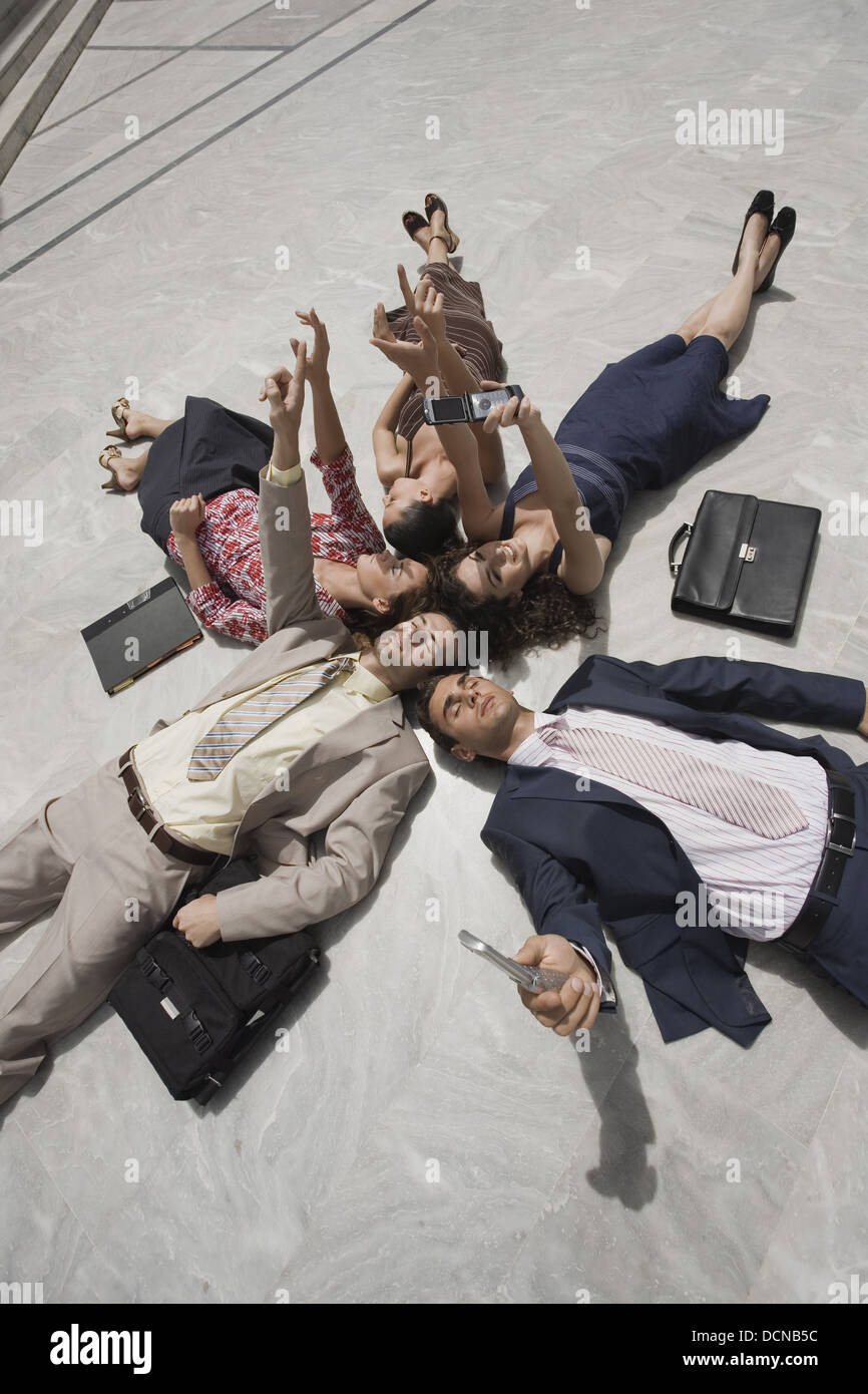 Business people lying on the ground Stock Photo - Alamy