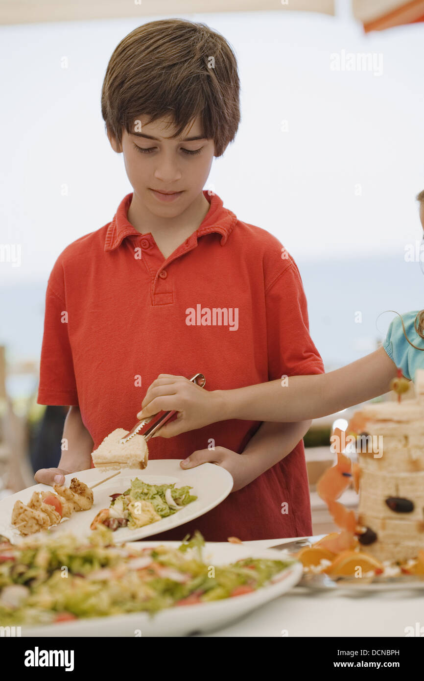 Boy being served by girl at buffet Stock Photo - Alamy