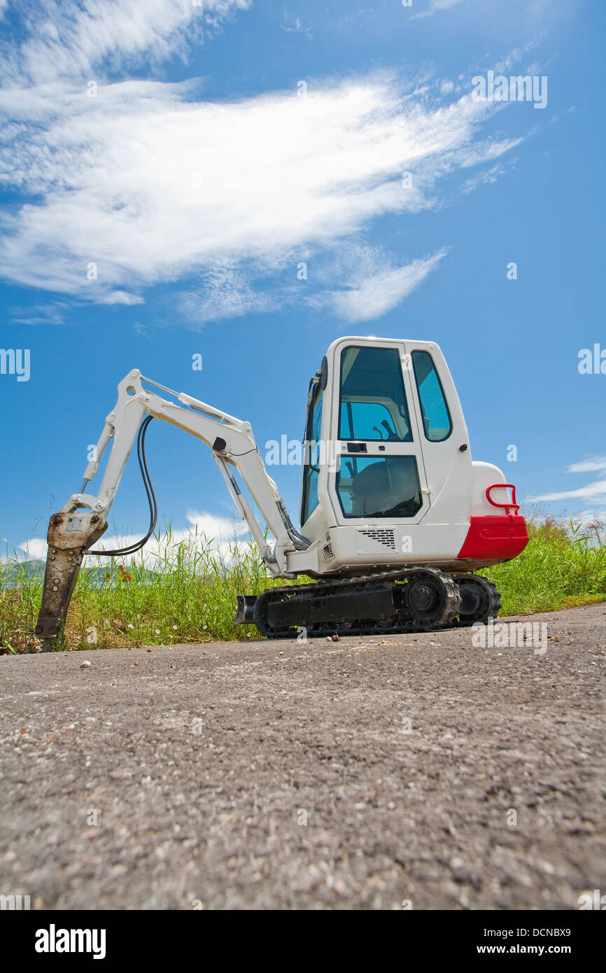 Small caterpillar tractor stands on the asphalt against the blue Stock ...