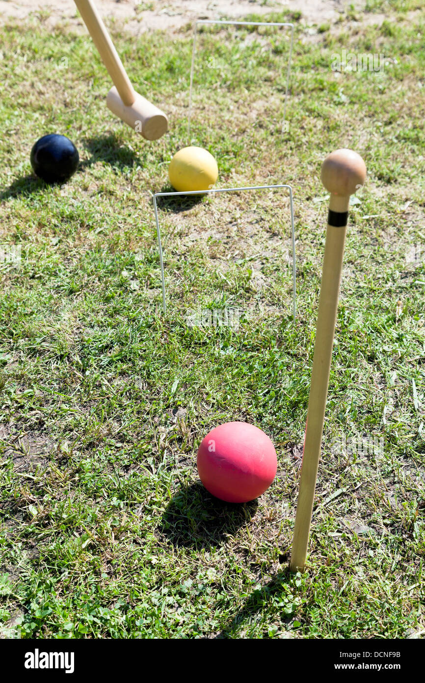 hitting of red ball in game of croquet on green lawn Stock Photo - Alamy