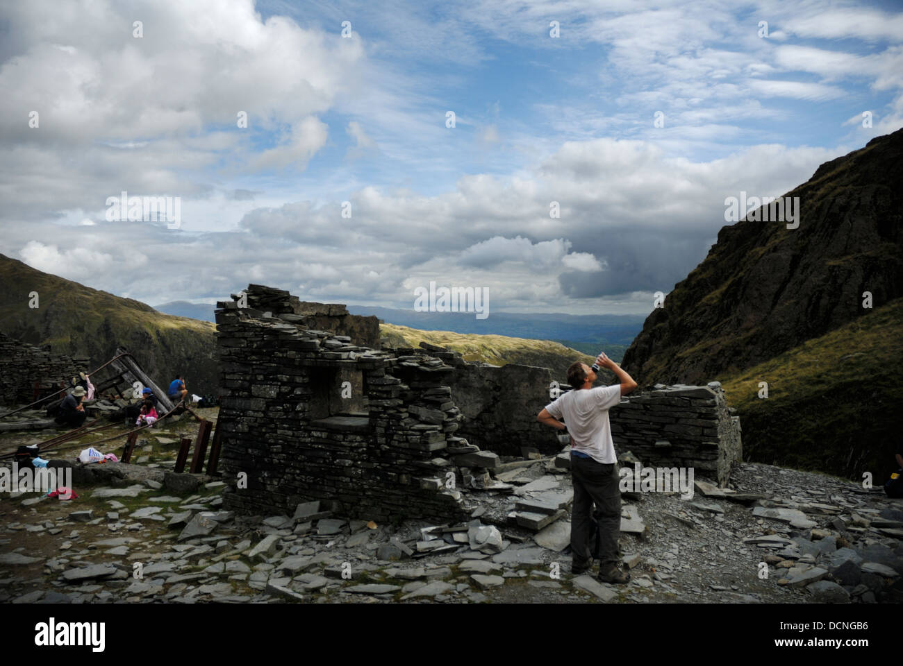 Walkers stop for rest and water at a disused slate mine on the side of ...