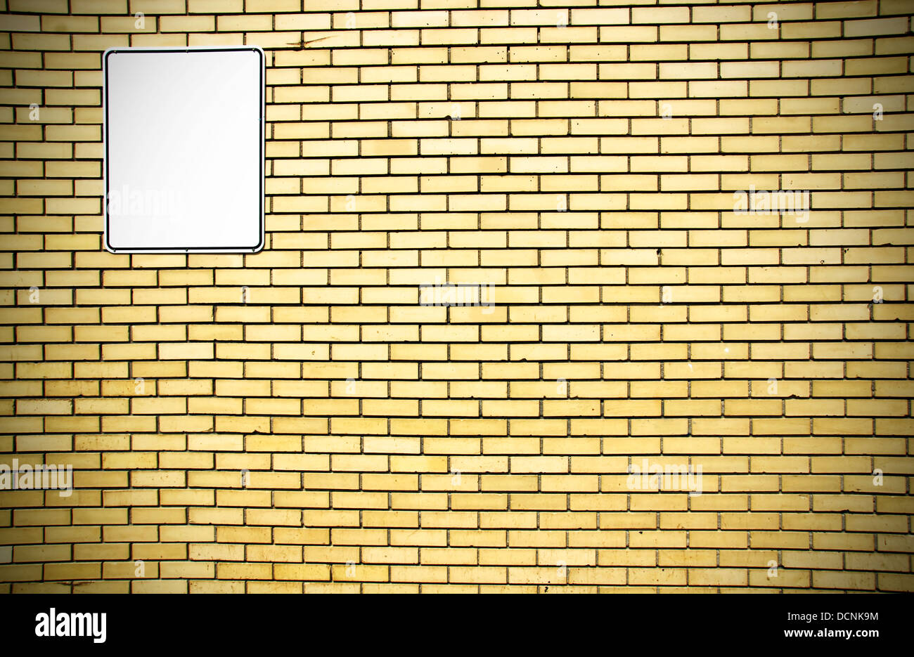 Yellow brick wall and white sign Stock Photo - Alamy