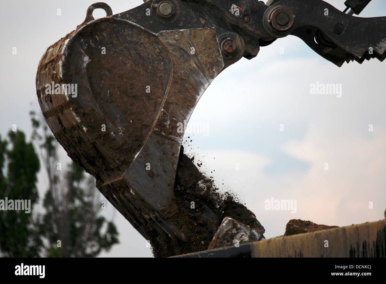 Excavator bucket emptying Stock Photo - Alamy