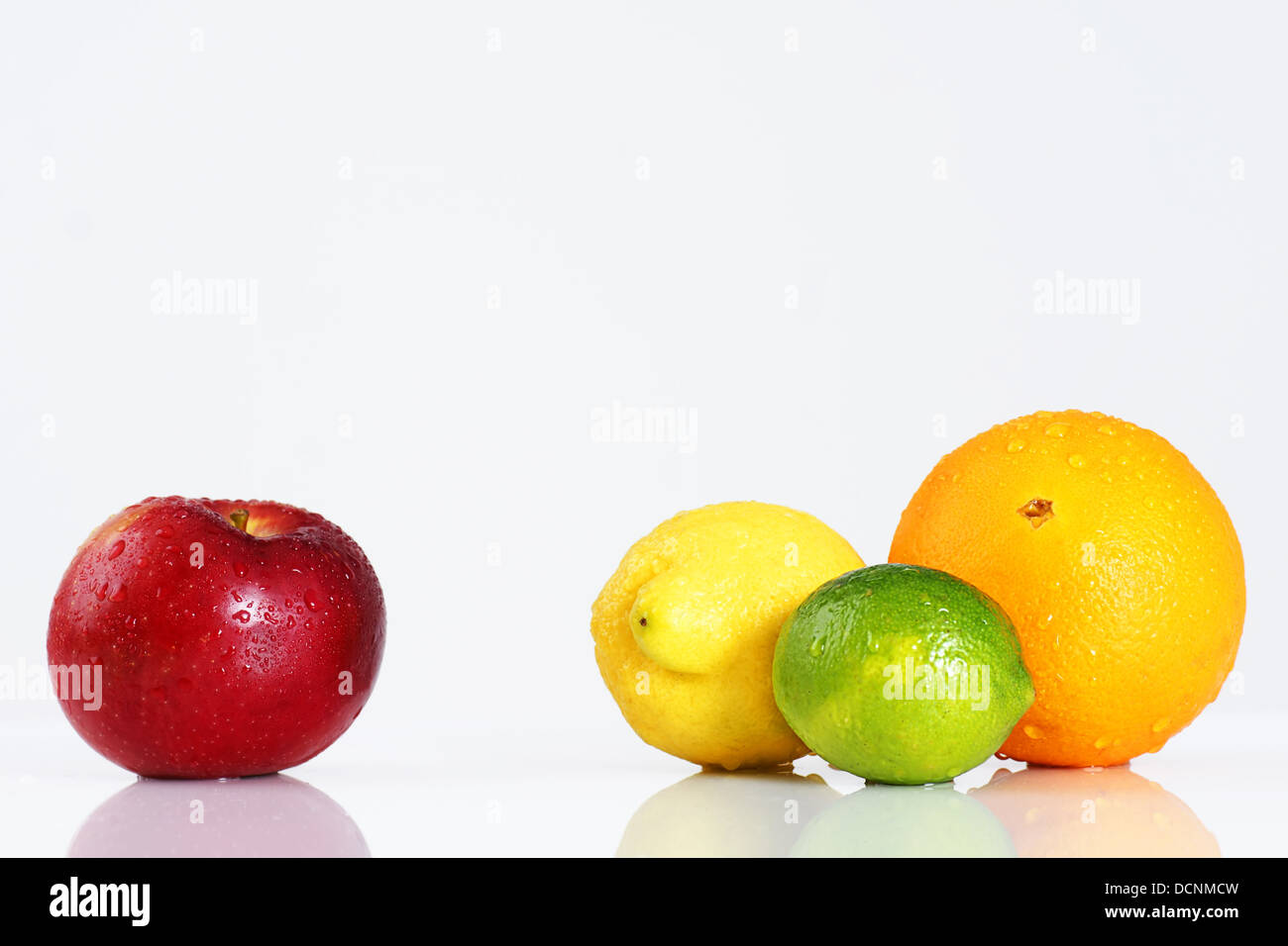 Apple compared to citrus fruits over white Stock Photo - Alamy