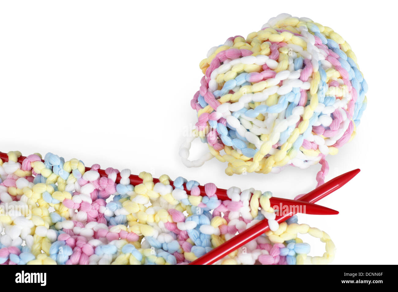 Red needles and baby colors knitting Stock Photo - Alamy