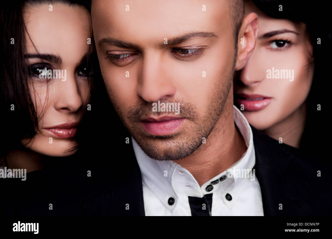 Two women faces behind male Stock Photo - Alamy