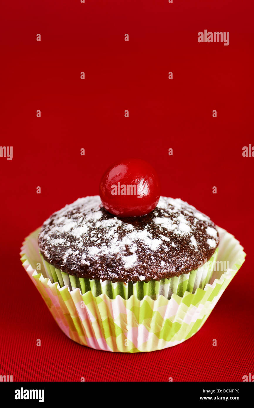 One chocolate cupcake with cherry over red Stock Photo - Alamy
