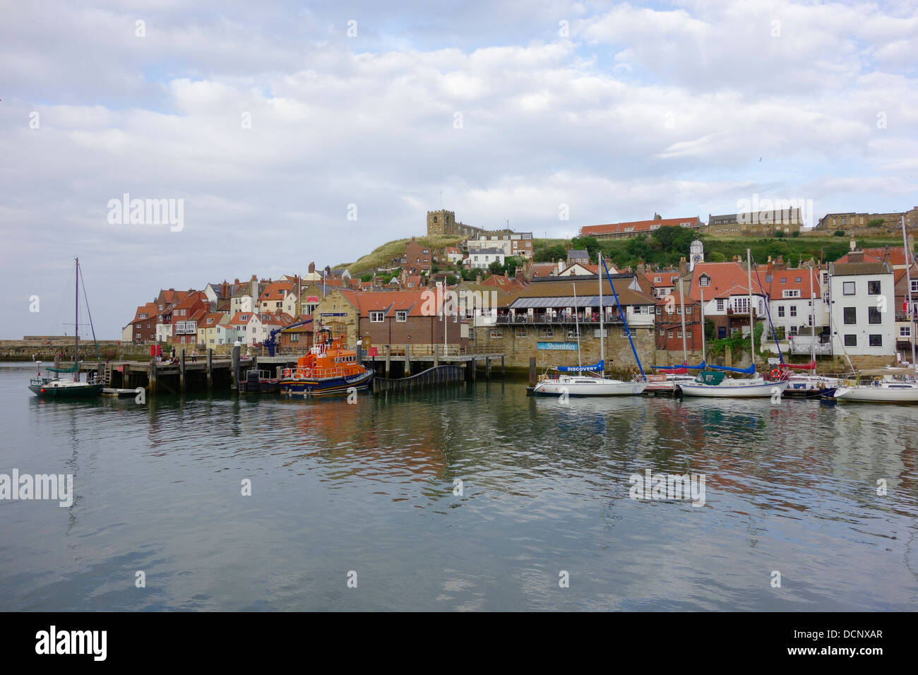 Whitby harbour with the lifeboat station and St Mary's church in summer ...