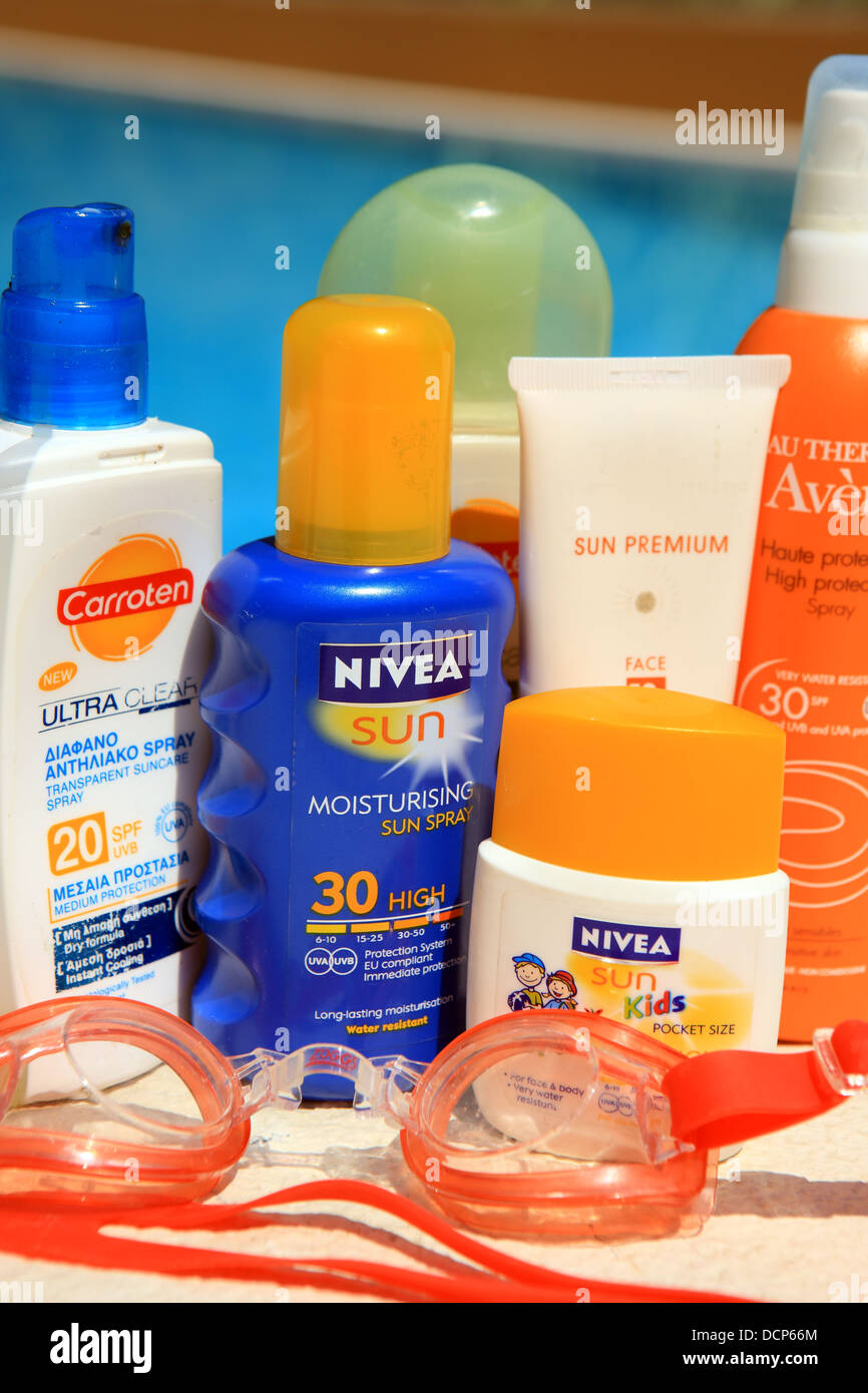 Bottles of various sunscreen products by the swimming pool Stock Photo ...