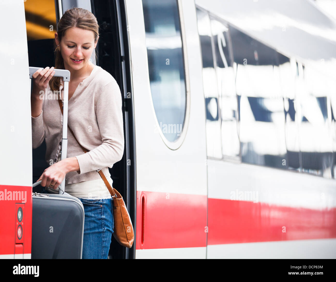 Pretty young woman boarding a train Stock Photo - Alamy