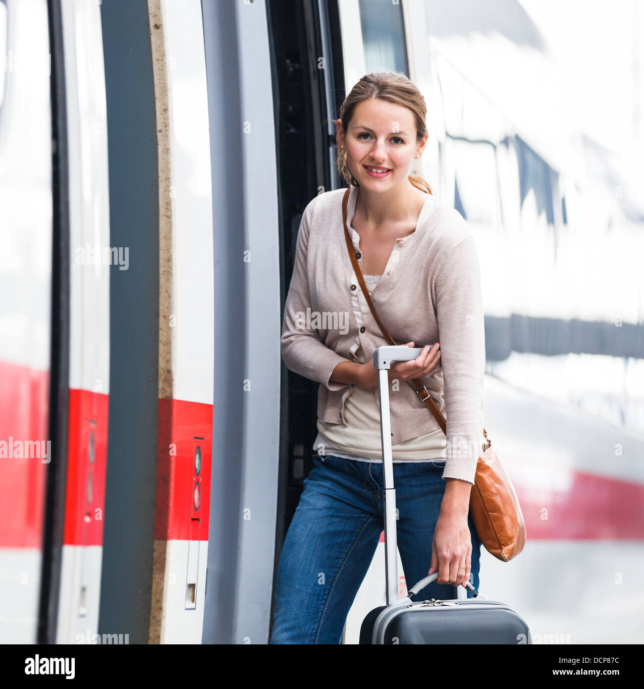 Pretty young woman boarding a train Stock Photo - Alamy