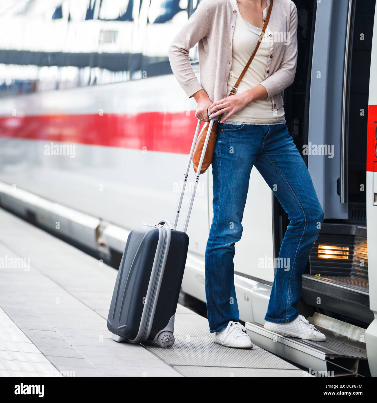 Pretty young woman boarding a train Stock Photo - Alamy