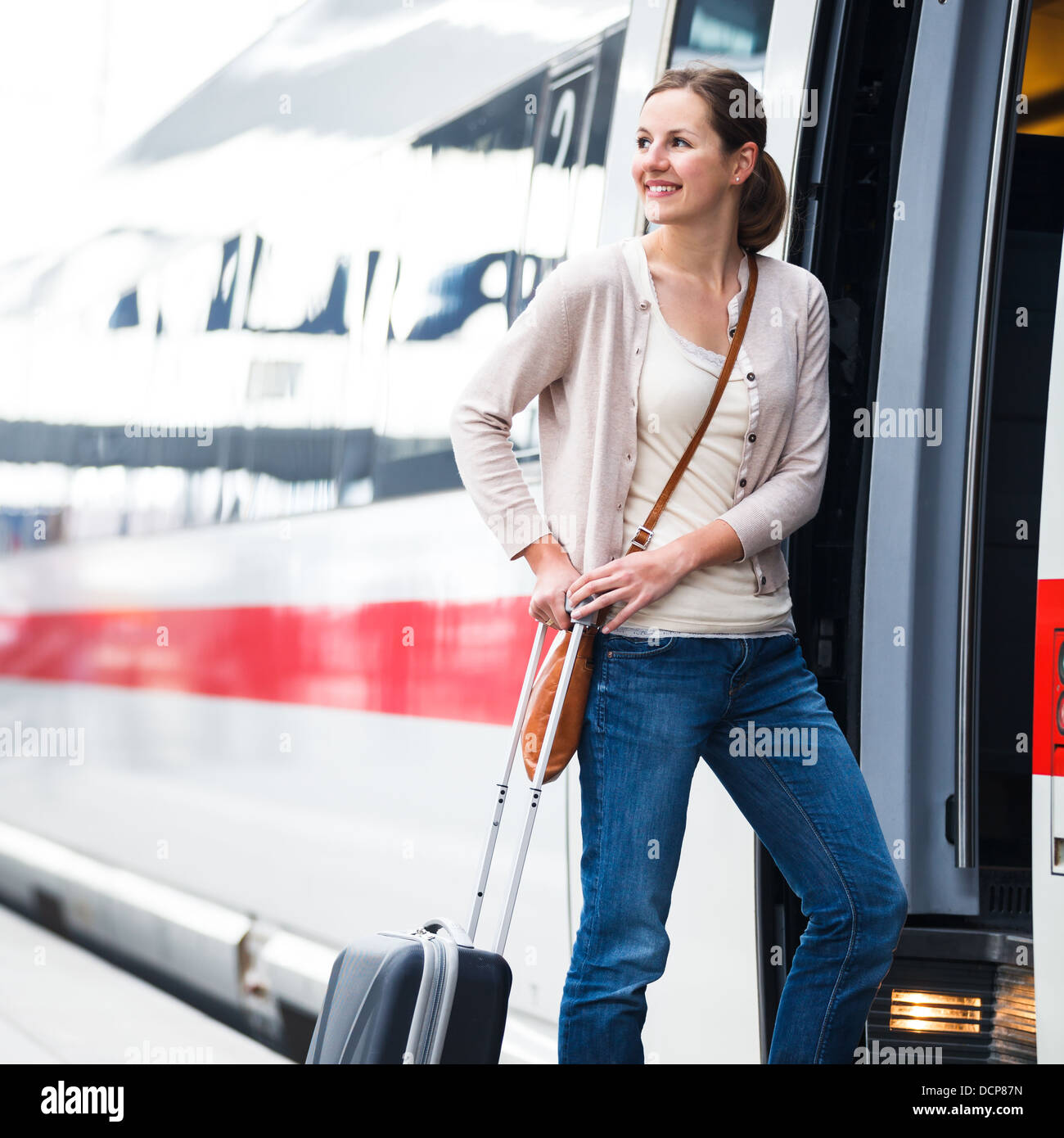 Pretty young woman boarding a train Stock Photo - Alamy