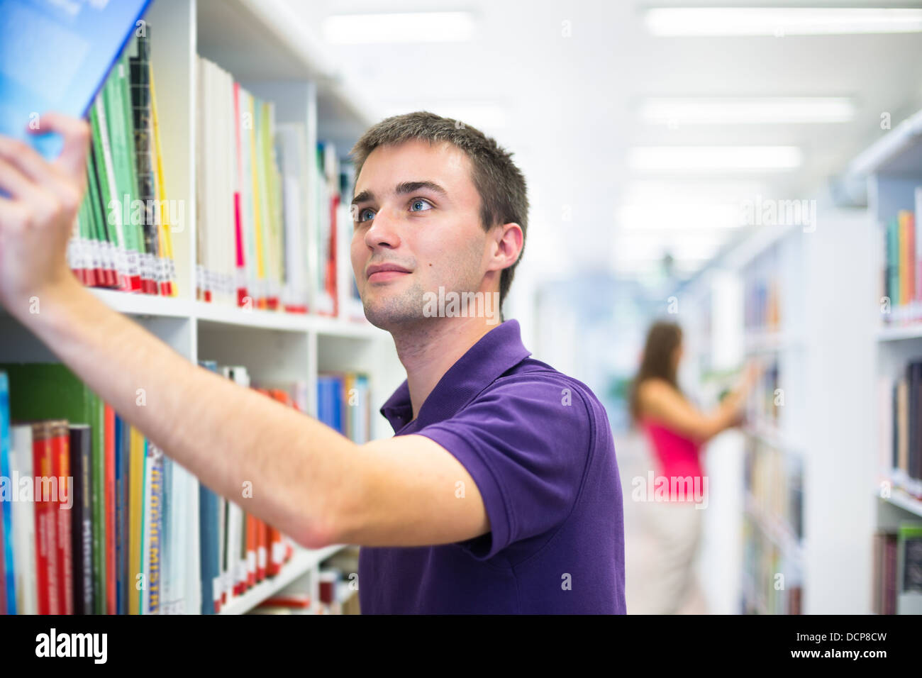 Handsome college student in library Stock Photo - Alamy