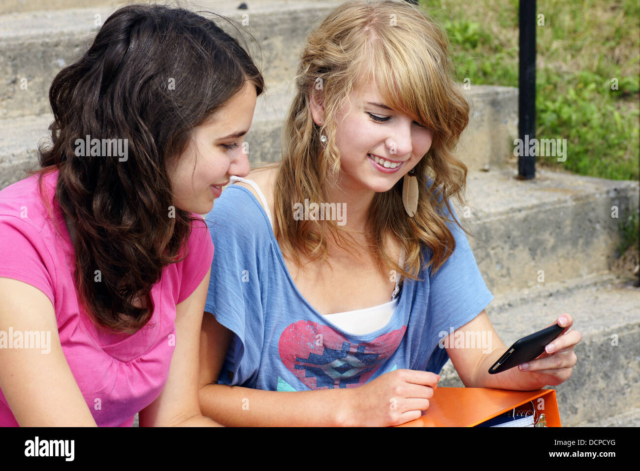 Two students reading on cell phone Stock Photo - Alamy