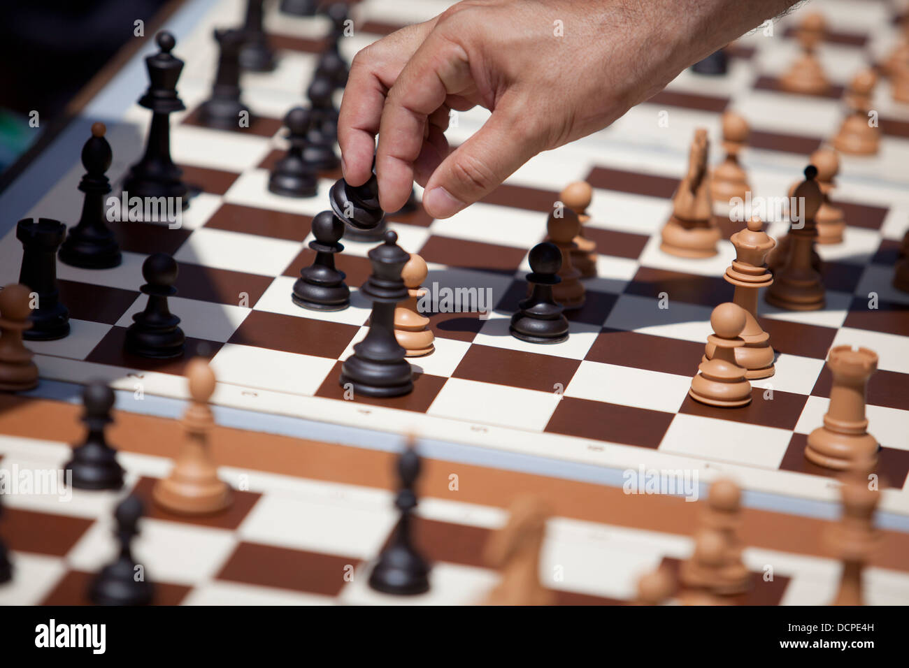 man playing chess, making the move Stock Photo - Alamy