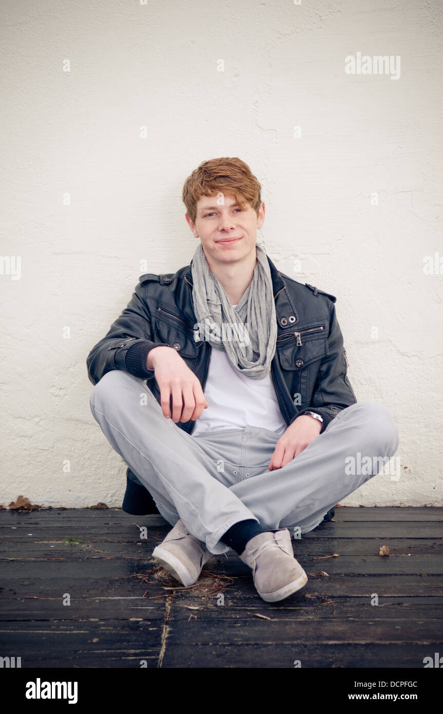 Cool young man sitting on the floor Stock Photo - Alamy