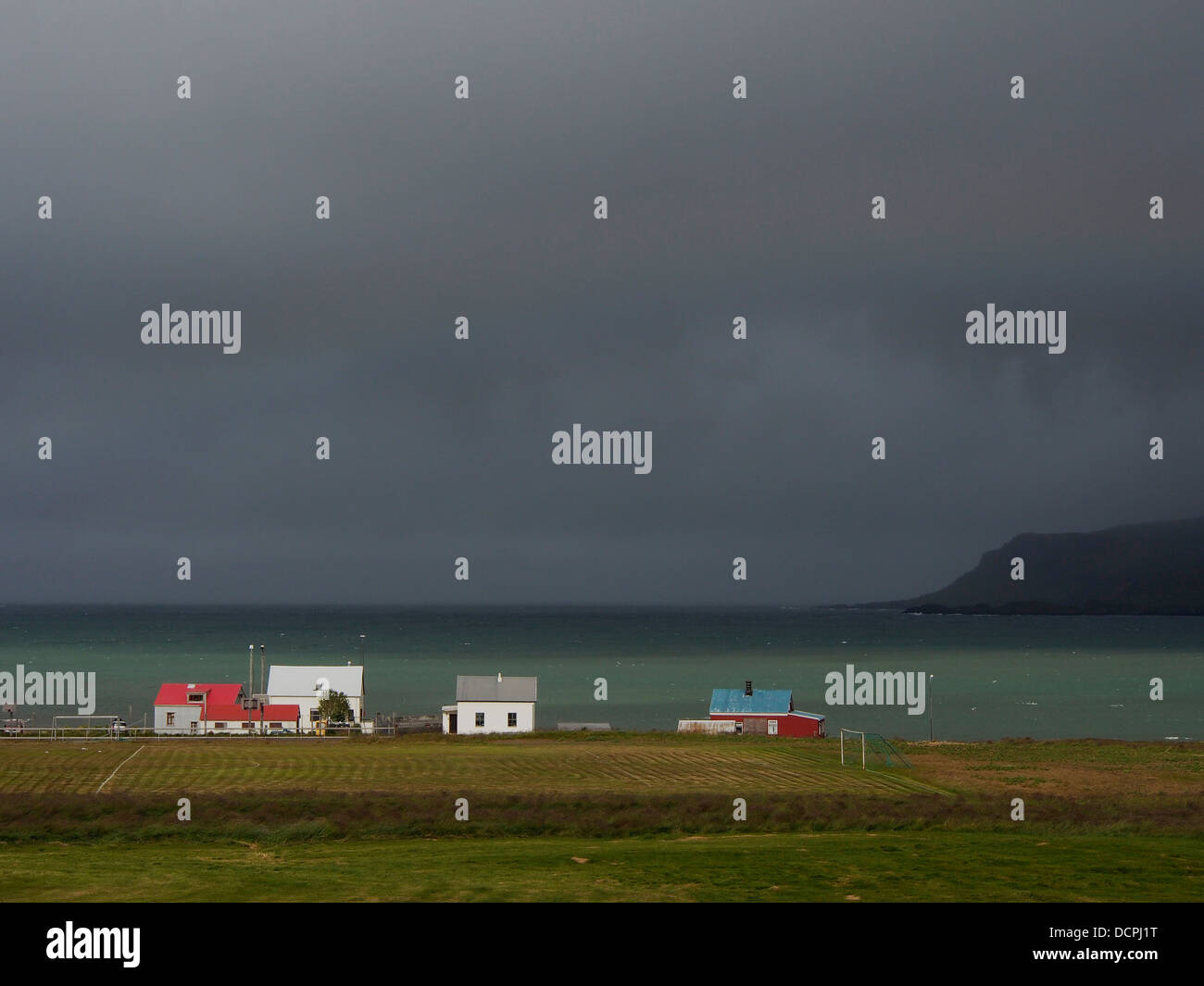Dark rain clouds over houses, Bakkagerði, Borgarfjörður Eystri, Iceland ...