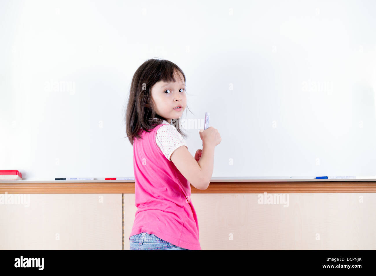 Child at whiteboard looking back Stock Photo - Alamy