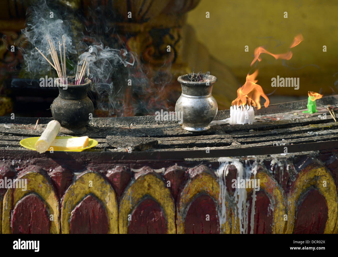 Incense sticks and sacrificial offerings are posted on an altar at the ...