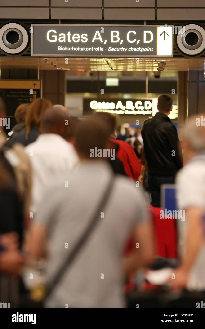Hamburg, Germany. 21st Aug, 2013. Passengers wait in line at a check-in ...
