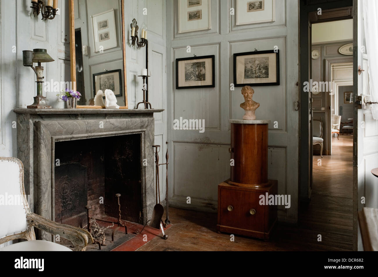 Stone fireplace and marble topped circular plinth in room with wood ...