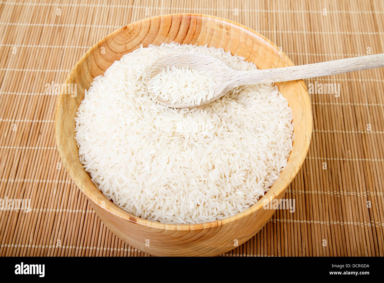 White rice with wood spoon in wood bowl on bamboo mat Stock Photo - Alamy