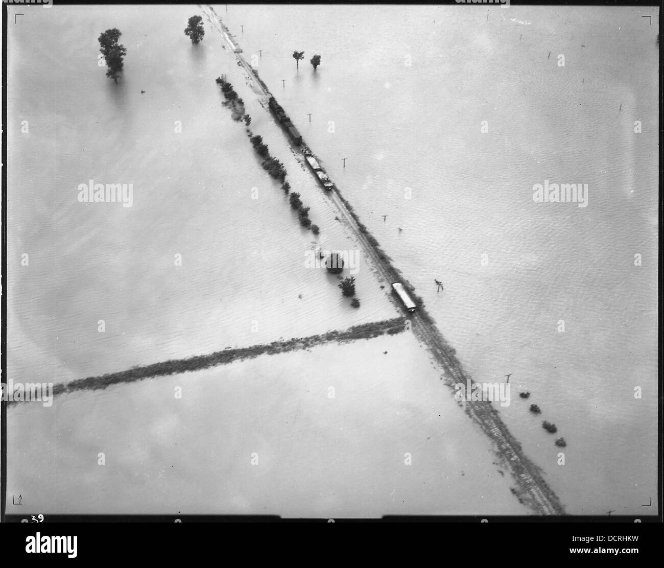 An aerial view captures a train stranded on flooded tracks ...