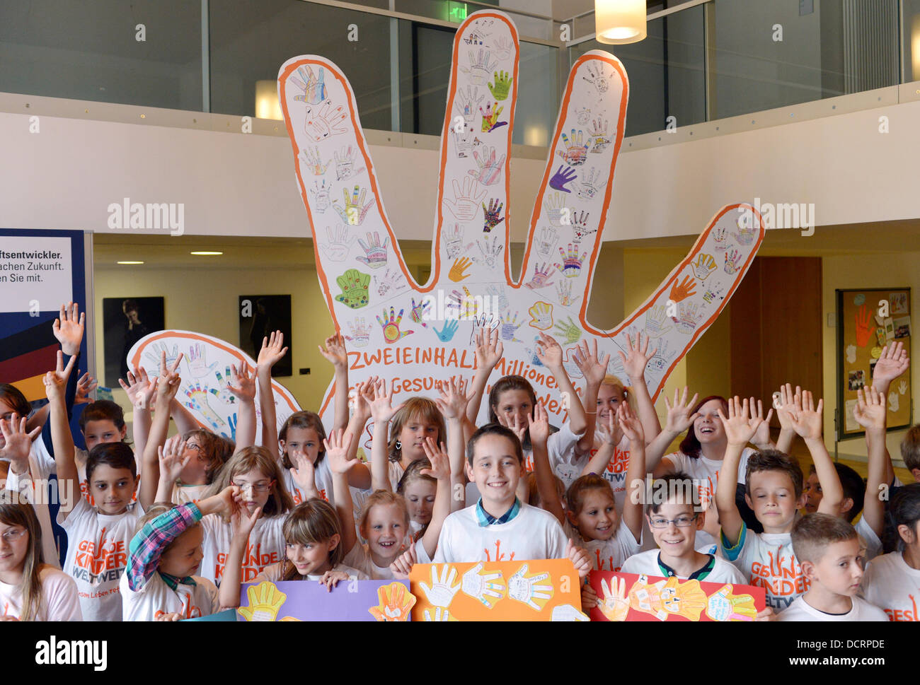 Berlin, Germany. 21st Aug, 2013. Children raise their hands in front of ...