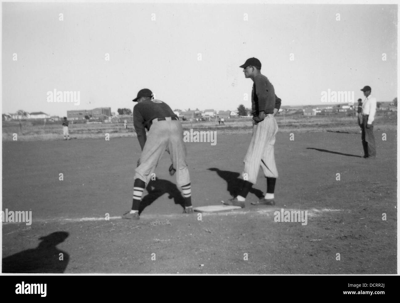 A scene from a baseball game showing a runner on base. The game is in ...